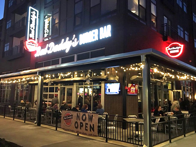 Night falls but burger dreams rise at Bad Daddy's, where neon lights promise delicious decisions ahead.