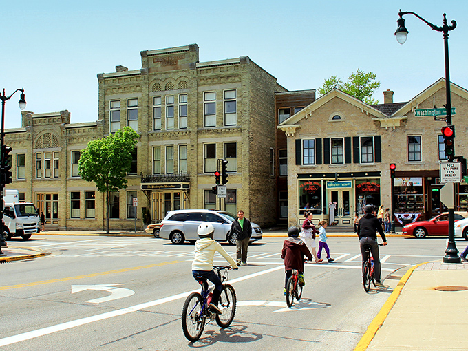 Historic stone buildings stand shoulder to shoulder in downtown Cedarburg, where cyclists and pedestrians share the streets in perfect harmony.
