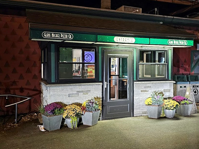 By night, Glass Nickel's warm glow and autumn flowers create the perfect pizza pilgrimage spot. The hardest decision? Whether to eat there or take it home.