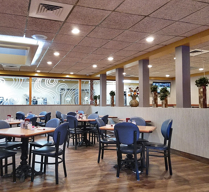 Classic diner comfort meets modern touches in this spacious dining room, where blue chairs and wooden tables create the perfect setting for memorable meals.