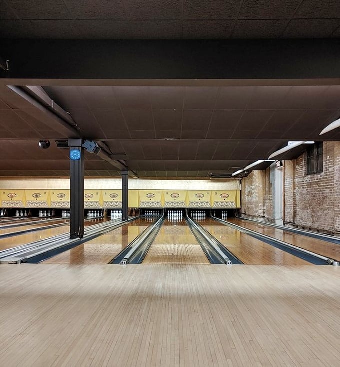 These gleaming wooden lanes have witnessed countless strikes, spares, and gutter balls since the 1960s. The yellow pin dividers and exposed brick walls? Pure retro perfection.