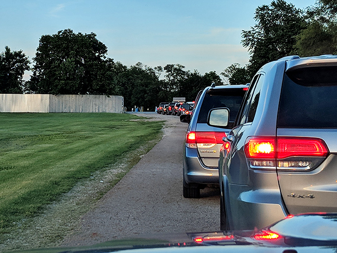 The ceremonial procession of moviegoers, each car a private living room on wheels, lined up for the quintessential American ritual.