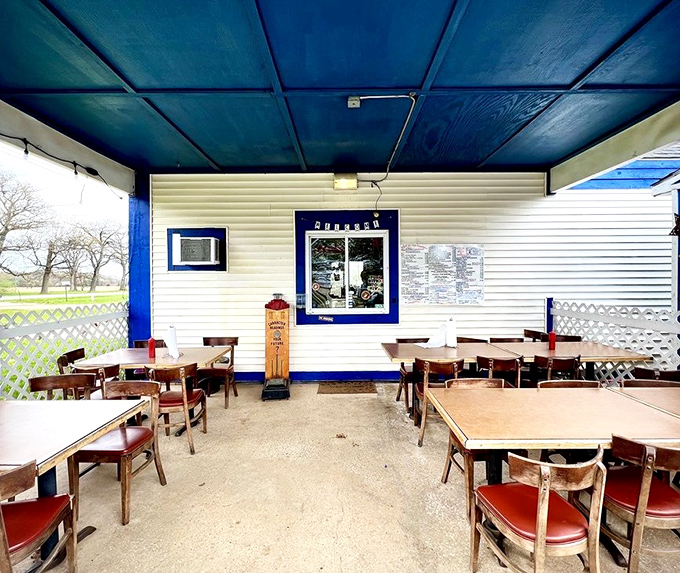 Under that vibrant blue ceiling, strangers become friends united by the universal language of exceptional burgers and shared tables.