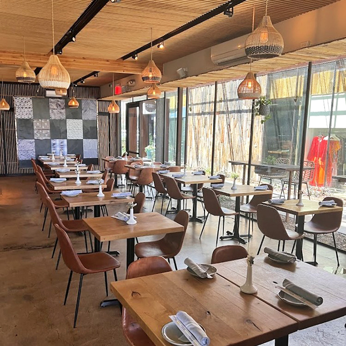 Warm wooden tables bathed in natural light create the perfect stage for the flavor drama about to unfold on your plate.