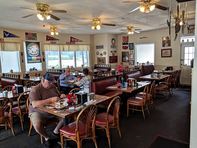 Inside, ceiling fans whirl lazily above burgundy booths where regulars and first-timers alike bond over plates of comfort food excellence.