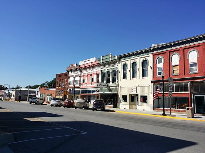 Sunlight bathes downtown Rock Port's preserved brick buildings in golden warmth. The American flag flutters gently, completing this Norman Rockwell-worthy scene.