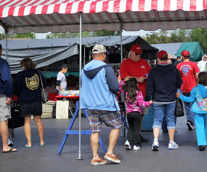 The red and white striped canopies create a carnival atmosphere where shoppers navigate the labyrinth of potential finds.