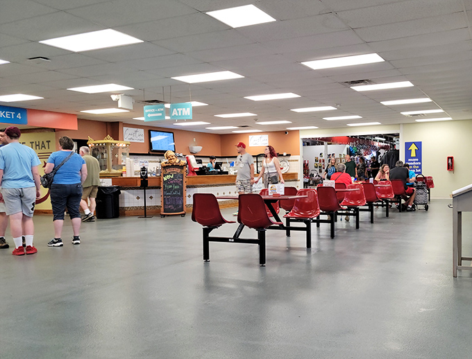 The food court: civilization's oldest compromise between shopping stamina and hunger pangs. Red chairs await weary treasure hunters needing to refuel before the next expedition.