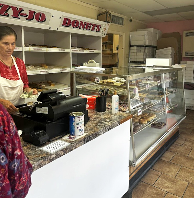 Behind the counter, where donut dreams come true. The display cases might not be fancy, but what they hold is pure edible artistry.