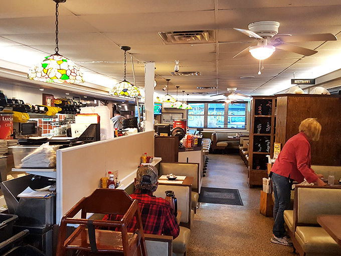 Stained glass pendant lights cast a warm glow over vinyl booths where culinary magic happens. It's like dining in your favorite aunt's kitchen&mdash;if she made legendary cheesesteaks.