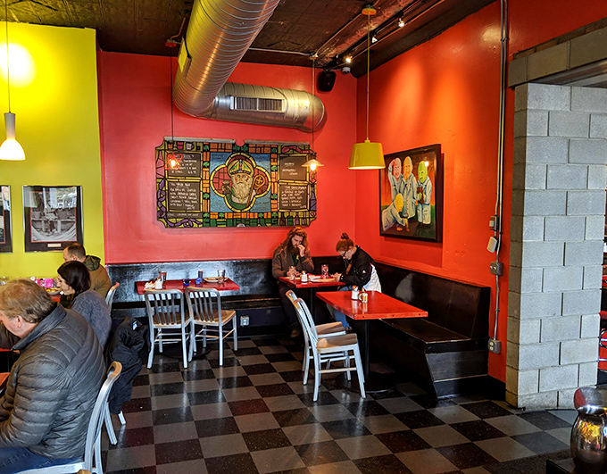 Vibrant red and yellow walls frame a checkerboard floor, creating a space that feels like a modern art gallery where the main exhibit is breakfast.