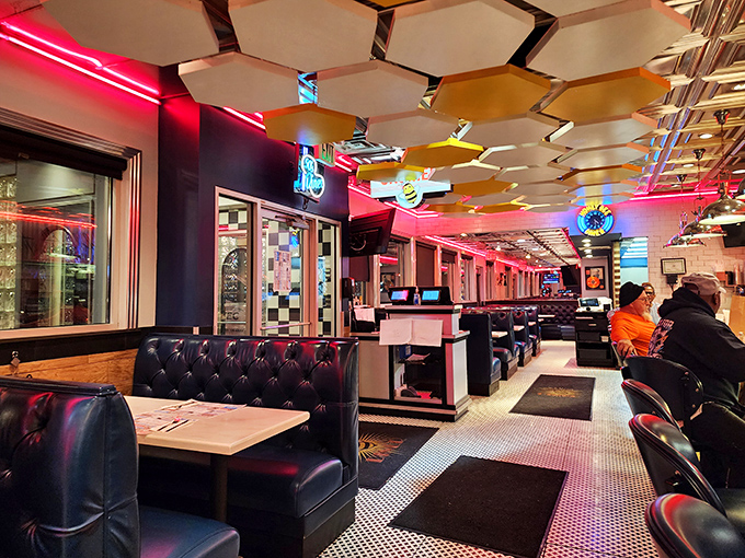 Step into a neon-lit time machine where honeycomb ceiling panels and plush leather booths create the perfect backdrop for breakfast epiphanies.