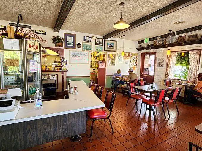 Classic diner ambiance at its finest&mdash;red chairs, terra cotta floors, and walls adorned with memories create the perfect backdrop for morning conversations.