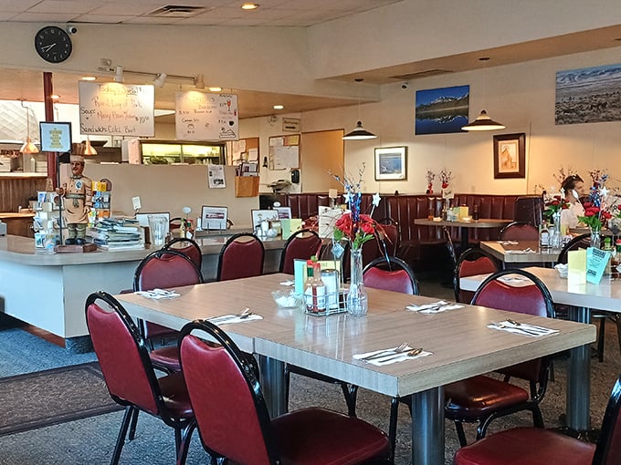 Classic red vinyl booths and burgundy chairs create that timeless diner atmosphere where conversations flow as freely as the coffee refills.