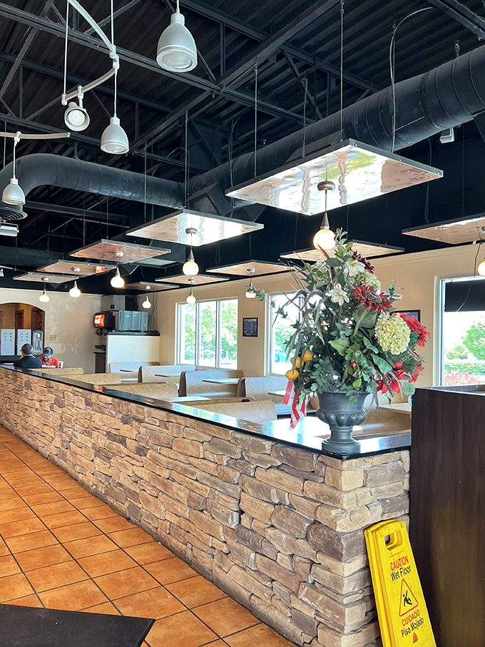 Industrial-chic meets cozy comfort with exposed ductwork above and warm stone below&mdash;a perfect backdrop for the pizza magic that happens here.