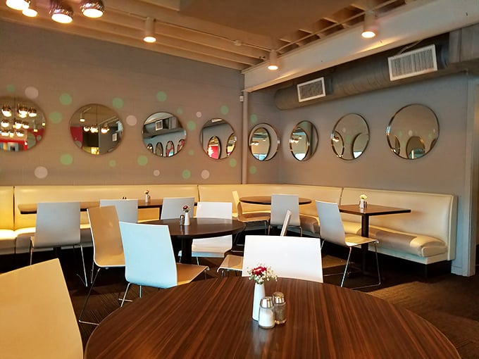 Mid-century meets modern with those playful circular mirrors and polka dot walls. The kind of clean, inviting space that makes coffee taste better. 