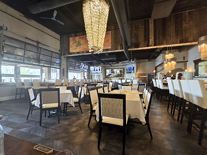 Elegant chandeliers illuminate white tablecloths while rustic wooden beams overhead create that perfect "fancy but not fussy" atmosphere we all crave.