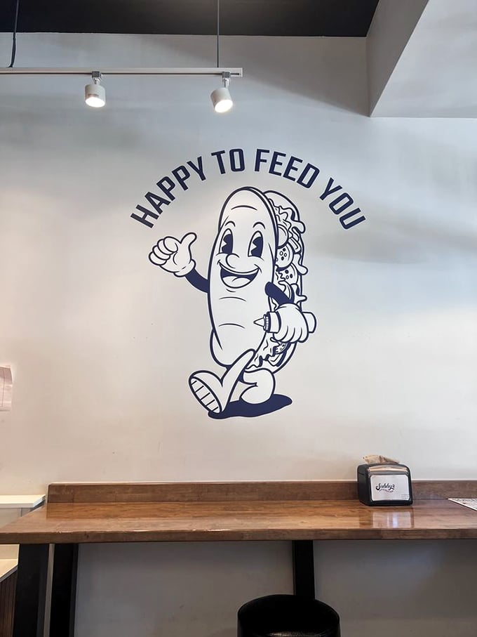 That cheerful sandwich mascot says it all: "HAPPY TO FEED YOU." Has there ever been a more honest restaurant motto?
