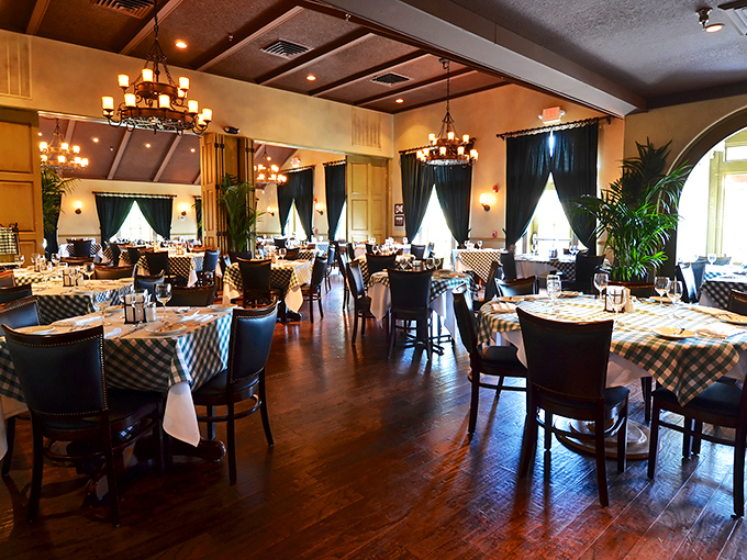 Classic checkered tablecloths meet elegant chandeliers in this dining room where comfort and sophistication dance a perfect waltz.