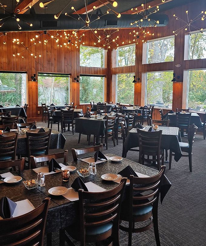 Starburst chandeliers dance above warm wood paneling, creating the perfect Wisconsin trifecta: cozy ambiance, nature views, and tables eagerly awaiting hungry patrons.