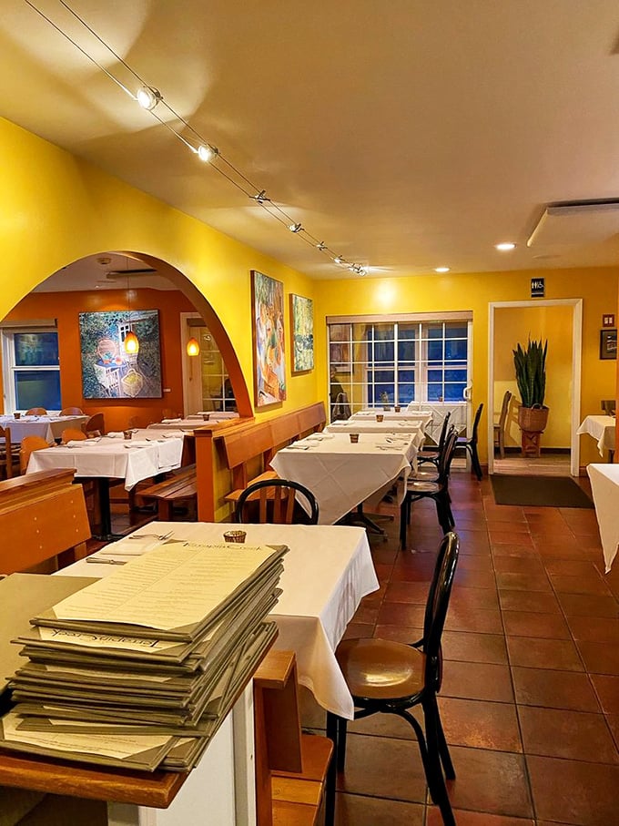 Warm yellow walls and crisp white tablecloths create the perfect canvas for culinary artistry, where every table feels like the best seat in the house.