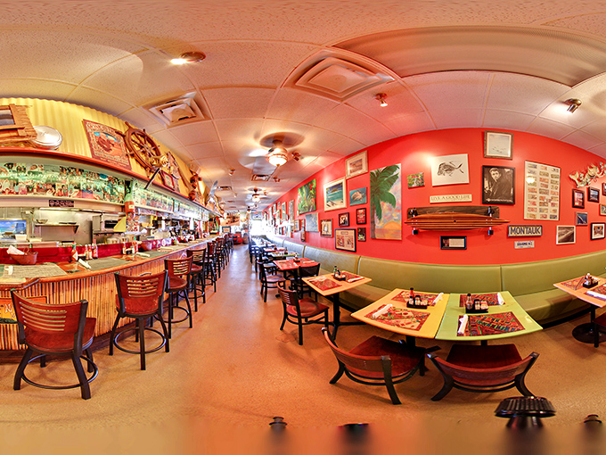 The vibrant coral walls and bamboo accents transform this narrow space into a tropical escape where every seat feels like the best in the house.