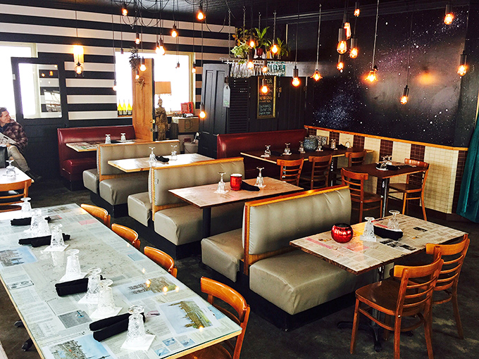 Step inside and you're transported to a world where Edison bulbs dance above cosmic murals and black-and-white stripes create a space that's both cozy and otherworldly.