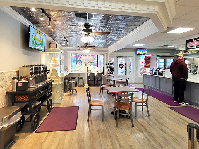 Step inside to discover a cozy interior where pressed tin ceilings and wooden floors create the perfect backdrop for your impending sugar-induced euphoria.