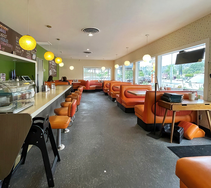 Orange vinyl booths and pendant lights create the perfect diner atmosphere where comfort food dreams come true.