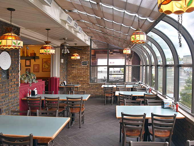 Stained glass lamps cast a warm glow over the solarium dining area, where Chicago's infamous weather stays outside while pizza perfection happens inside.