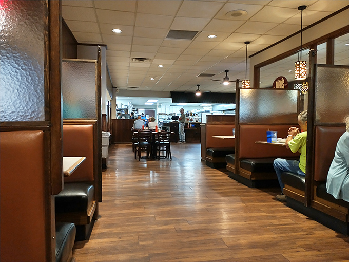 Classic wooden booths and warm lighting create that perfect small-town restaurant ambiance where conversations flow as freely as the coffee refills.