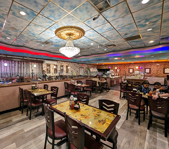 Beneath a sky-painted ceiling and crystal chandelier, diners enjoy the unexpected elegance that elevates this buffet experience beyond the ordinary.