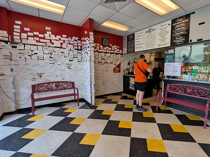 Classic pizzeria charm with those cream chairs and burgundy accents. The sports silhouettes in the dividers remind you you're in a place where memories are made.