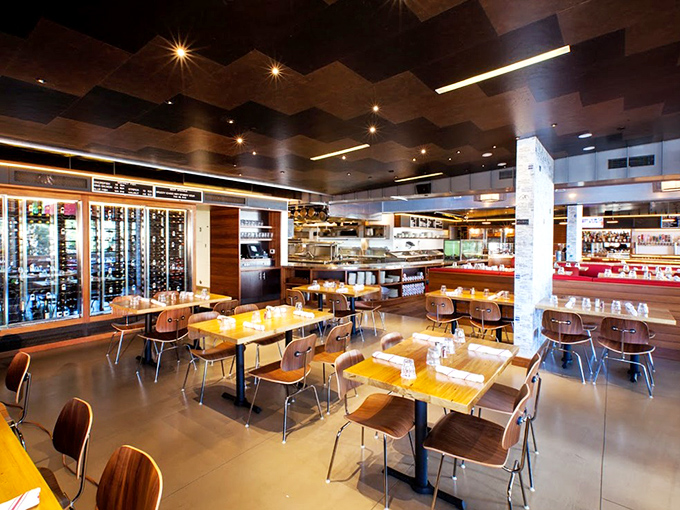 Inside, the geometric ceiling and warm wood tables create a space that's both sophisticated and comfortable&mdash;like the dining room of your coolest friend's beach house.