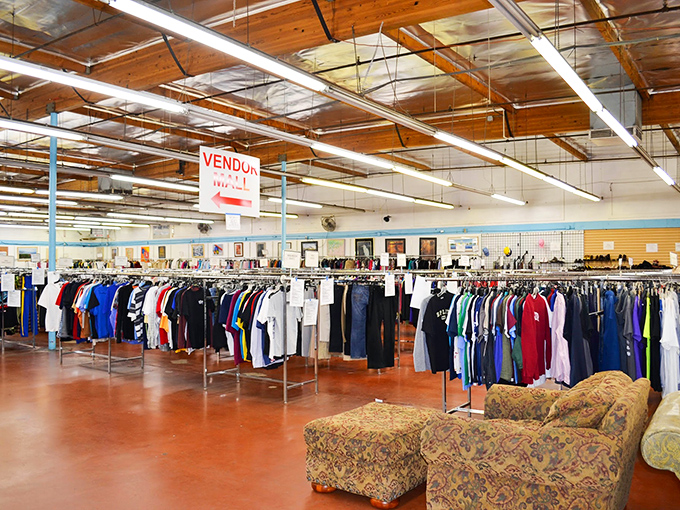 Endless racks of clothing stretch toward wooden beams, while a floral couch invites weary shoppers to rest their bargain-hunting legs.