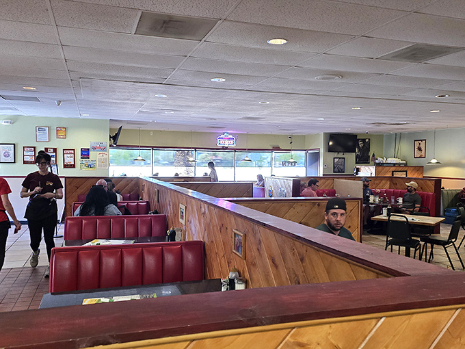 Classic red vinyl booths and wooden dividers create that time-capsule diner atmosphere where conversations flow as freely as the coffee.