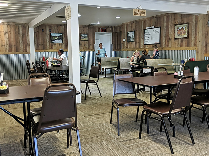 Rustic wood paneling meets corrugated metal in this dining room where comfort trumps pretension and conversations flow as freely as the sweet tea.