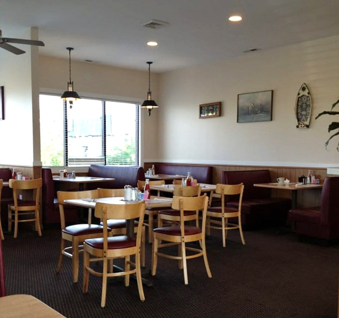 Simple wooden chairs, cozy burgundy booths, and warm lighting create that quintessential diner atmosphere where conversations flow as freely as the coffee.