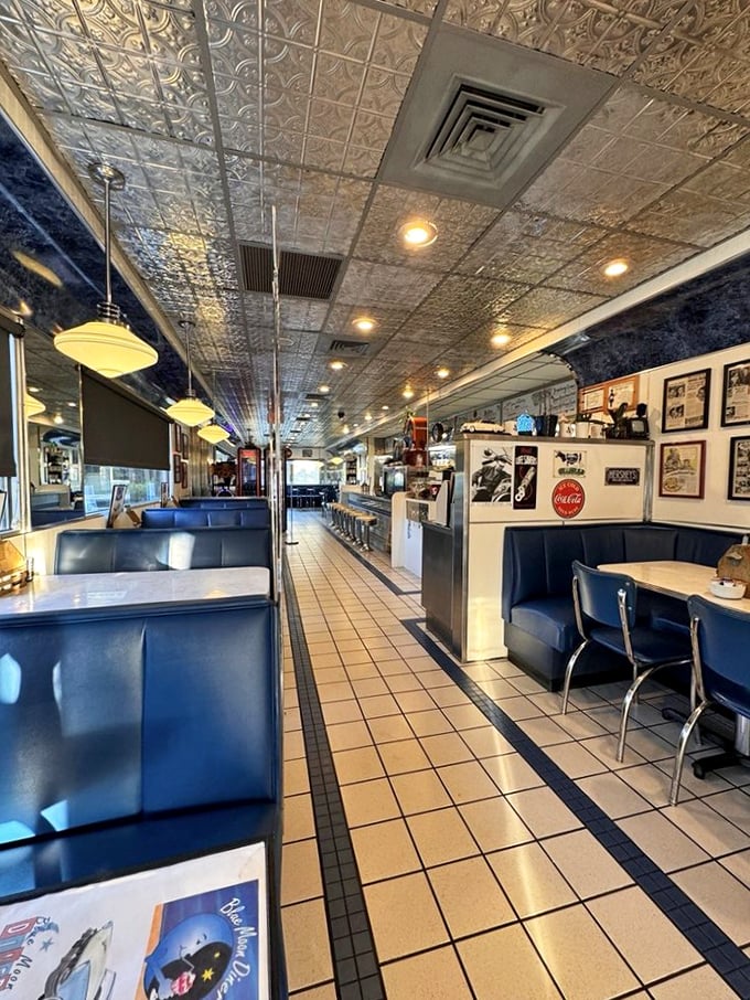 Classic Americana stretches before you inside Blue Moon Diner, where the embossed tin ceiling reflects decades of breakfast dreams and the promise of coffee refills.