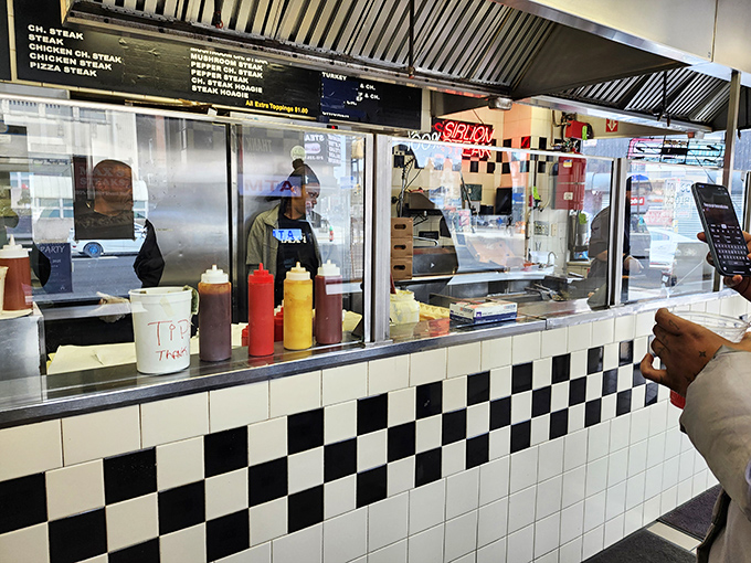 Behind the classic black and white checkered counter, culinary magic happens as orders fly and spatulas dance across the sizzling grill.