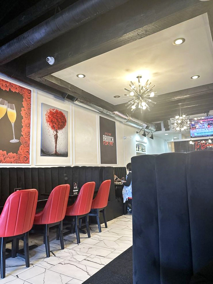 Starburst chandeliers cast a flattering glow over vibrant red chairs and sleek black booths, creating the perfect backdrop for brunch indulgence.