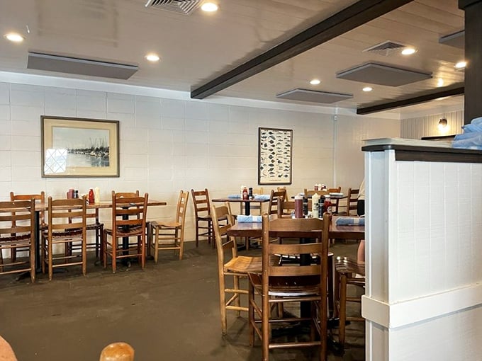 Simple wooden chairs and nautical-themed walls create that perfect "I've discovered something authentic" vibe. Comfort trumps pretension every time.