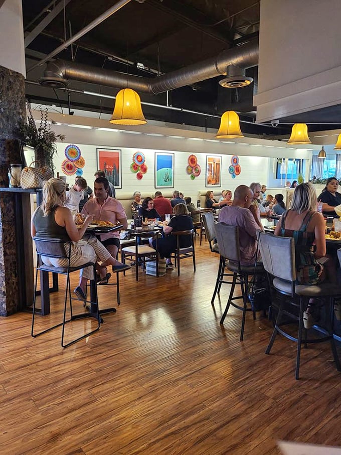 Where conversations flow as freely as the margaritas. Yellow pendant lights cast that perfect "everyone looks good here" glow over colorful folk art.