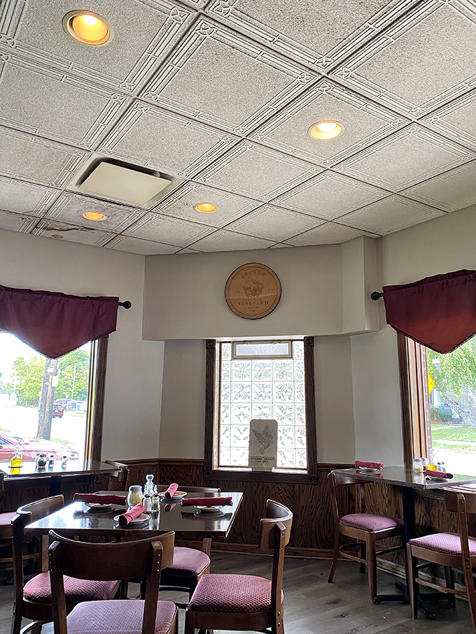 The dining room's vintage tin ceiling, burgundy accents, and warm lighting create that perfect "come stay awhile" atmosphere where conversations flow as freely as the wine.