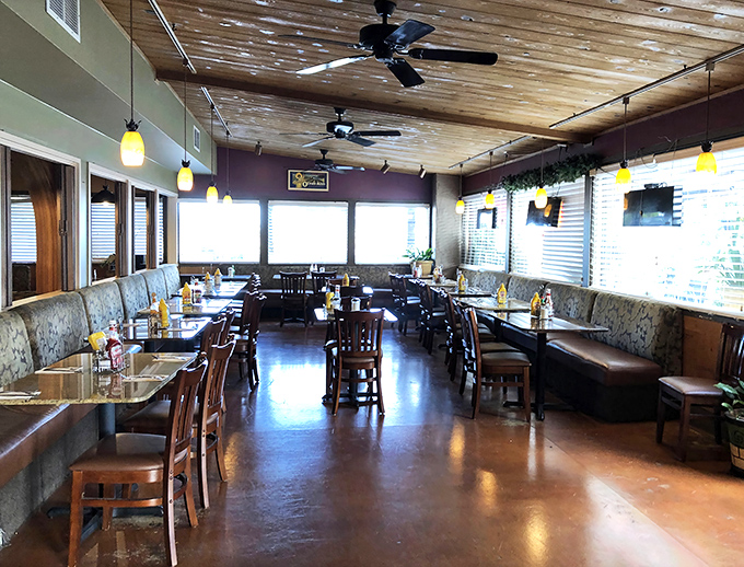 Cozy comfort awaits inside with wooden ceiling beams, booth seating, and pendant lighting that makes everyone look like they're ready for their Food Network close-up.
