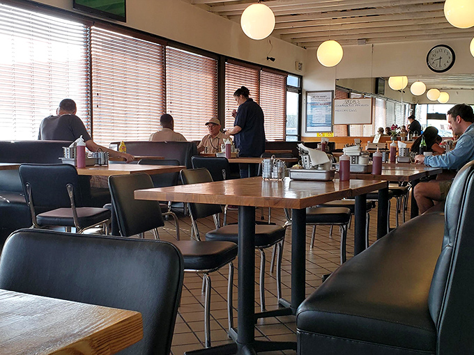 Inside, globe pendant lights cast a warm glow over wooden tables where breakfast dreams come true daily.