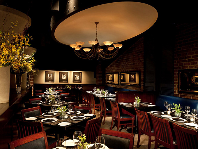 Elegant lighting casts a warm glow over rich wood furnishings, creating the perfect atmosphere for both celebration and quiet conversation.