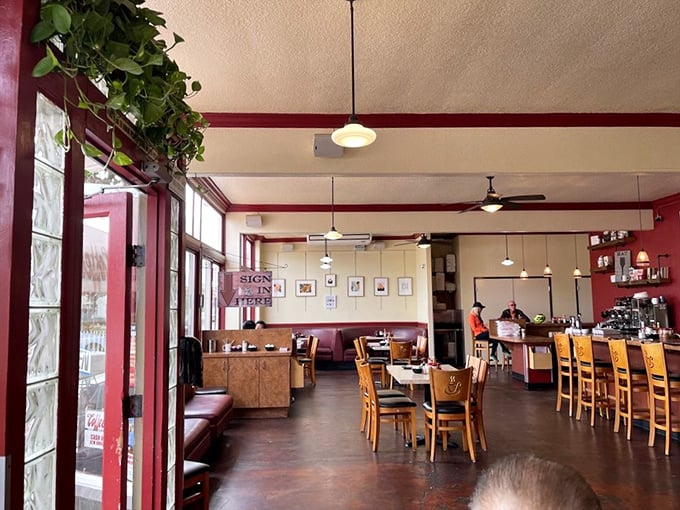 Inside, red walls and wooden chairs create the perfect diner harmony. Plants add life while pendant lights cast that magical "you're about to eat something amazing" glow.