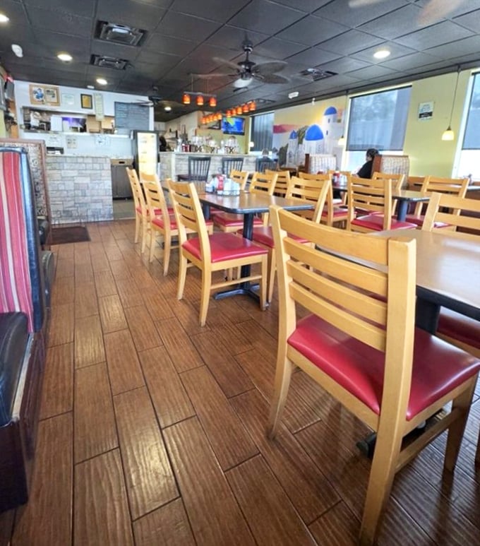 Inside, wooden floors and red-cushioned chairs create that perfect diner atmosphere where conversations flow as freely as the coffee.