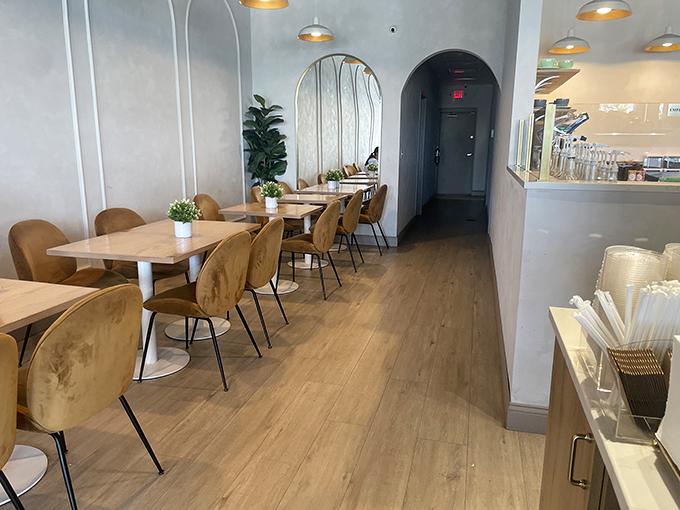 Minimalist chic meets cozy comfort in this thoughtfully designed interior. Those caramel chairs practically whisper, "Stay awhile, have another pastry."